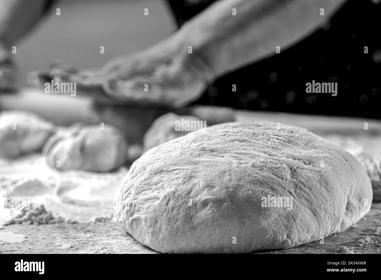 Dough, hand. Woman rolling out dough on kitchen table, close up. Black ...