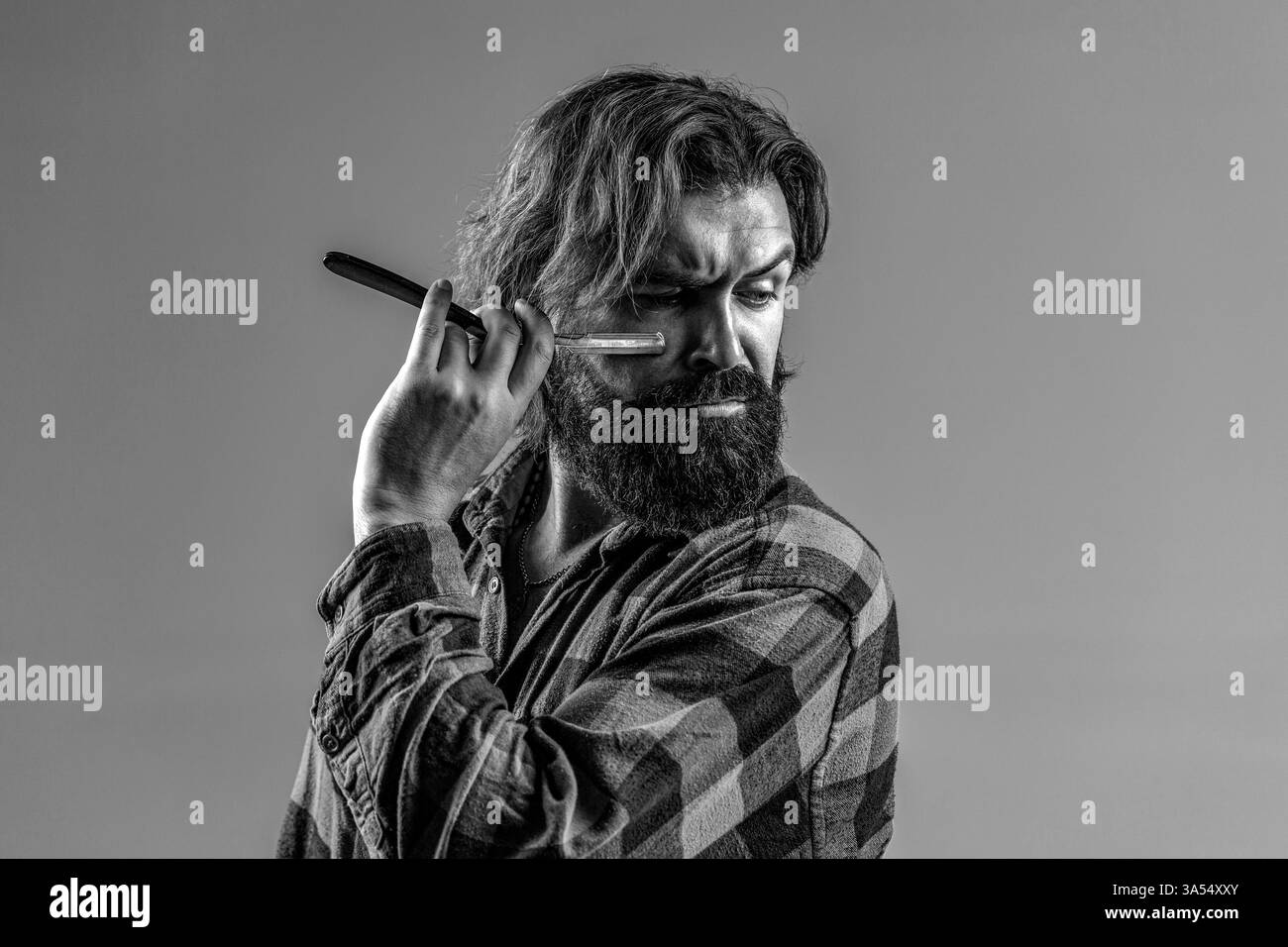 Man in barbershop. Man is holding a straight razor while barbershop ...
