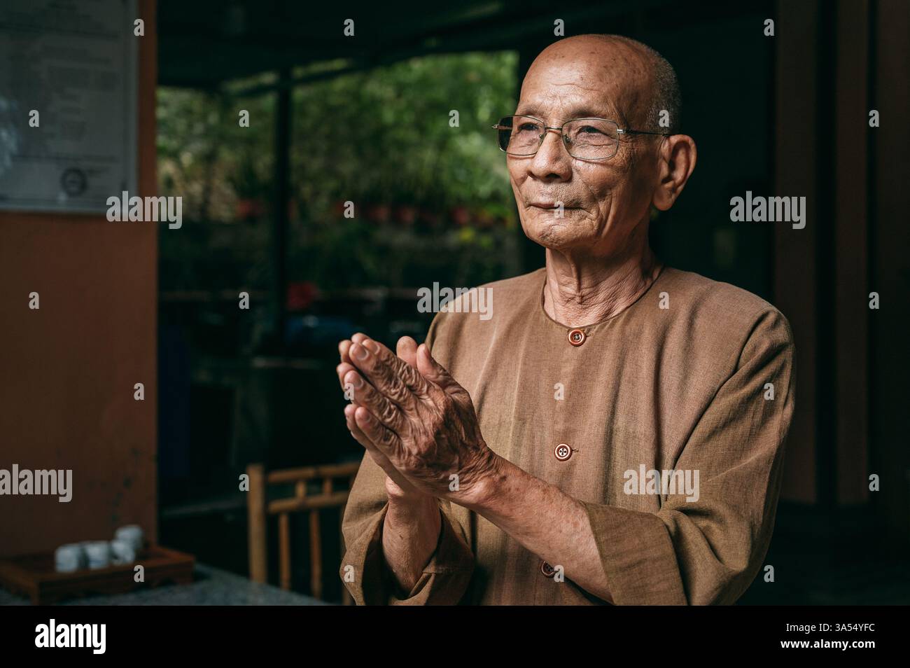 Portrait of elderly Asian Vietnamese male monk praying at Buddhist ...