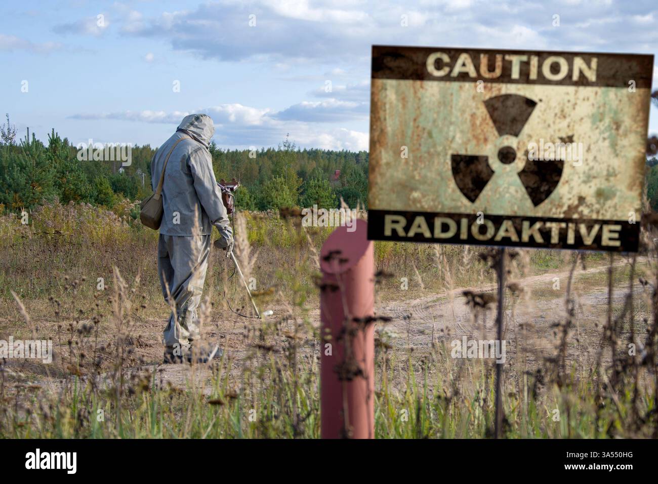 Military dosimetrist measures the radiation area, a sign with the ...