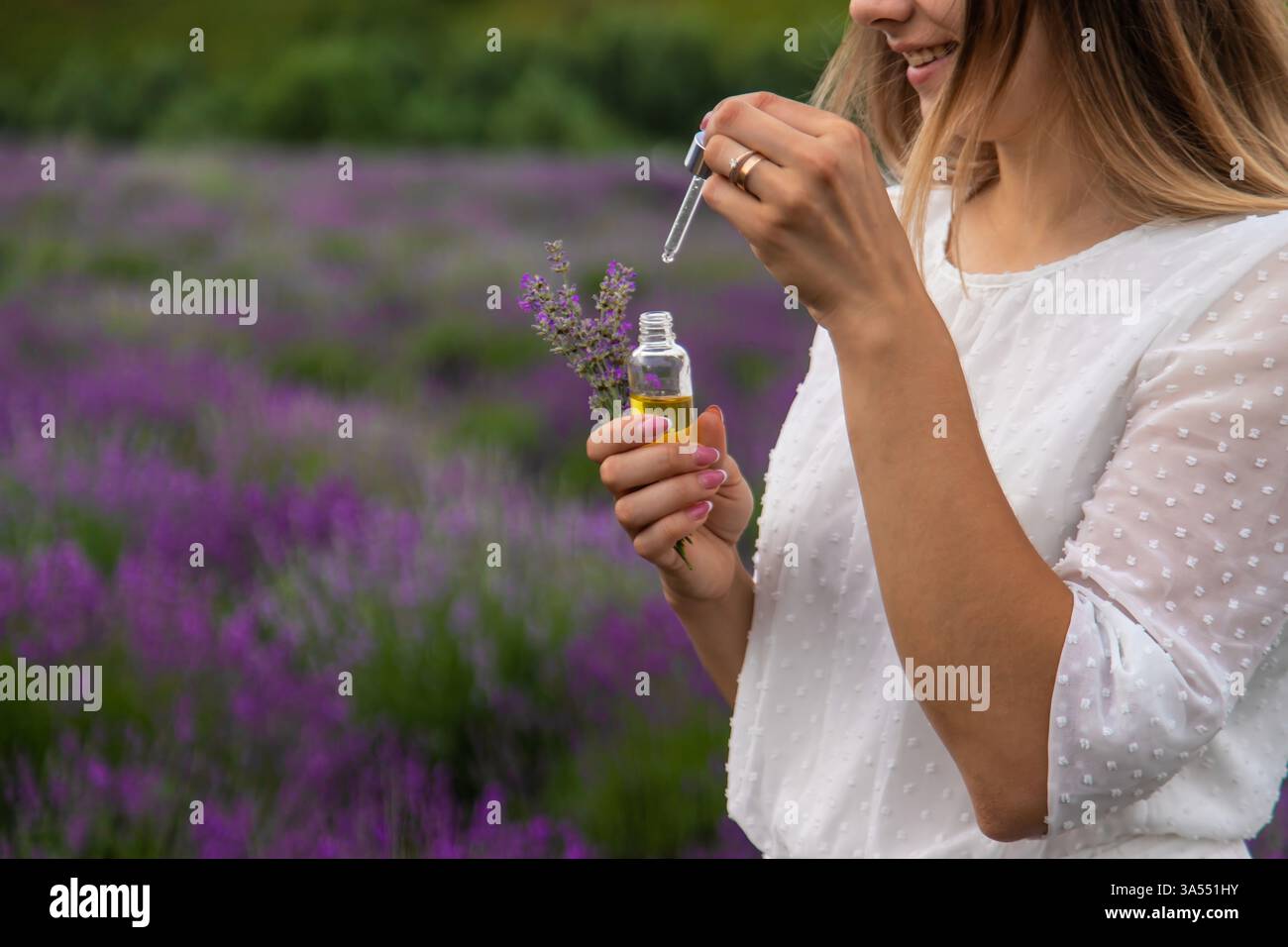 Woman in lavender field holding essential oil in her hands Stock Photo ...