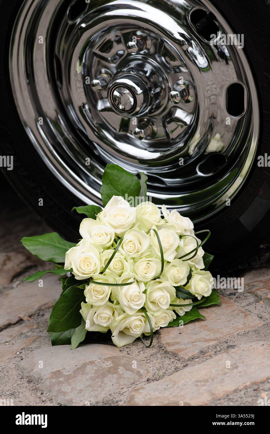 A sophisticated arrangement of white roses resting near a shiny chrome ...
