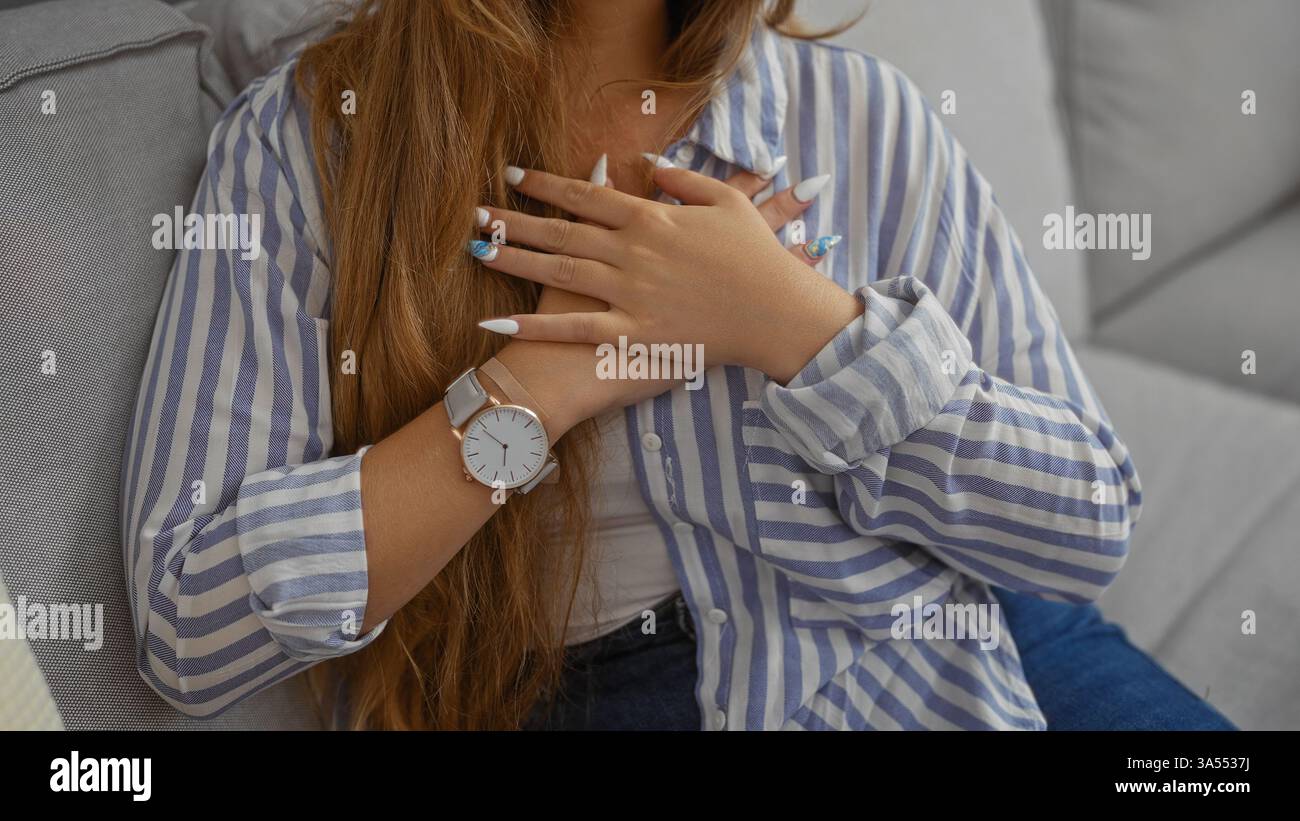 Young woman with long hair and painted nails wearing a striped shirt ...