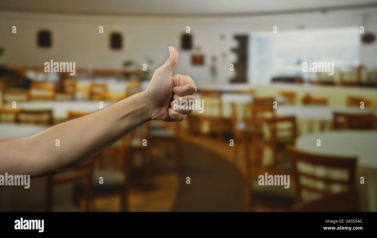 Man giving a thumbs-up indoors in a restaurant setting, highlighting a ...