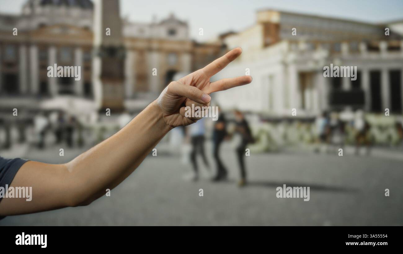 Hand of a man making a peace sign outdoors in st. peter's square ...