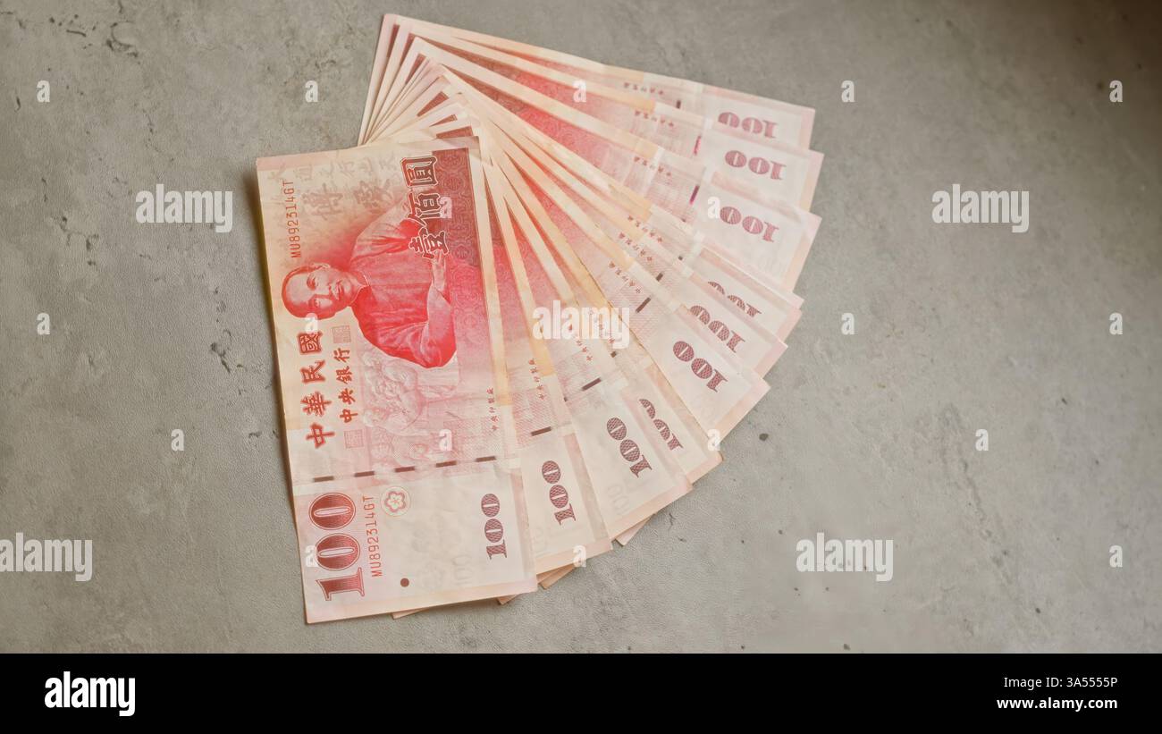 Chinese yuan banknotes fanned out on a concrete surface, showcasing ...