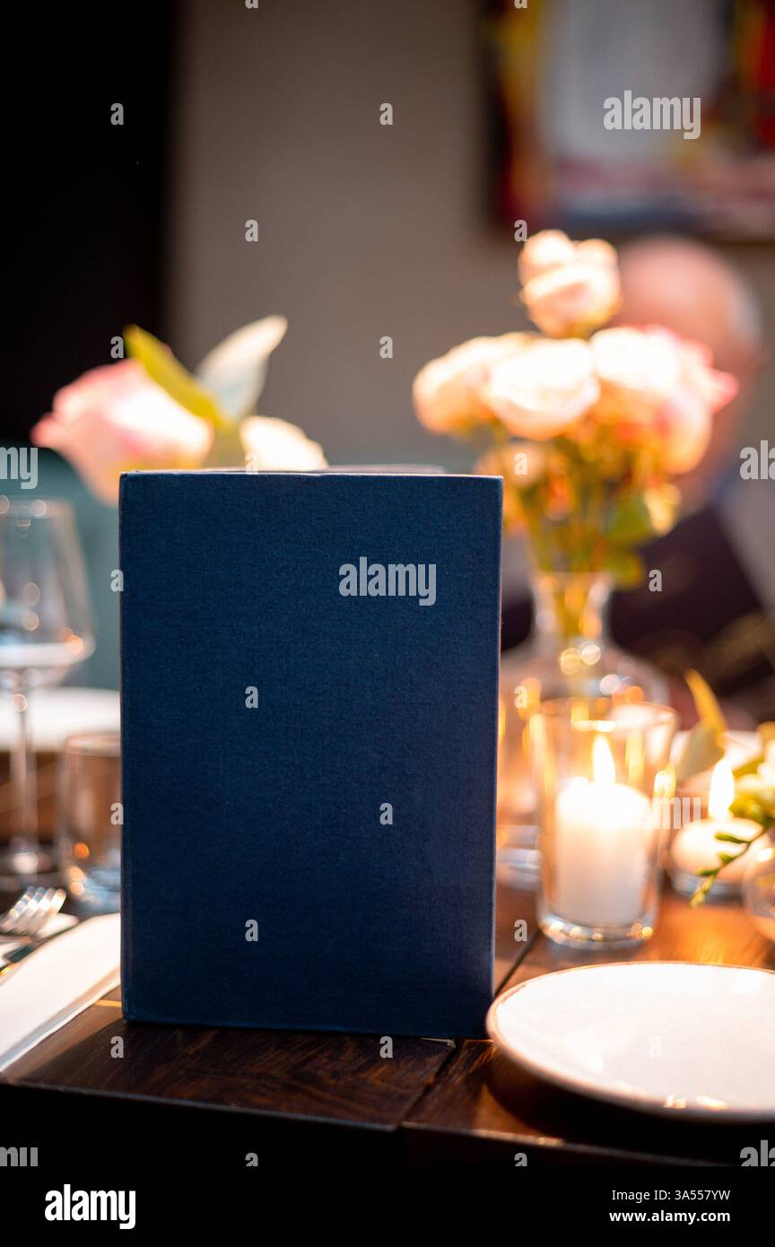 Elegant Restaurant Table Setting with Blue Menu Stock Photo - Alamy