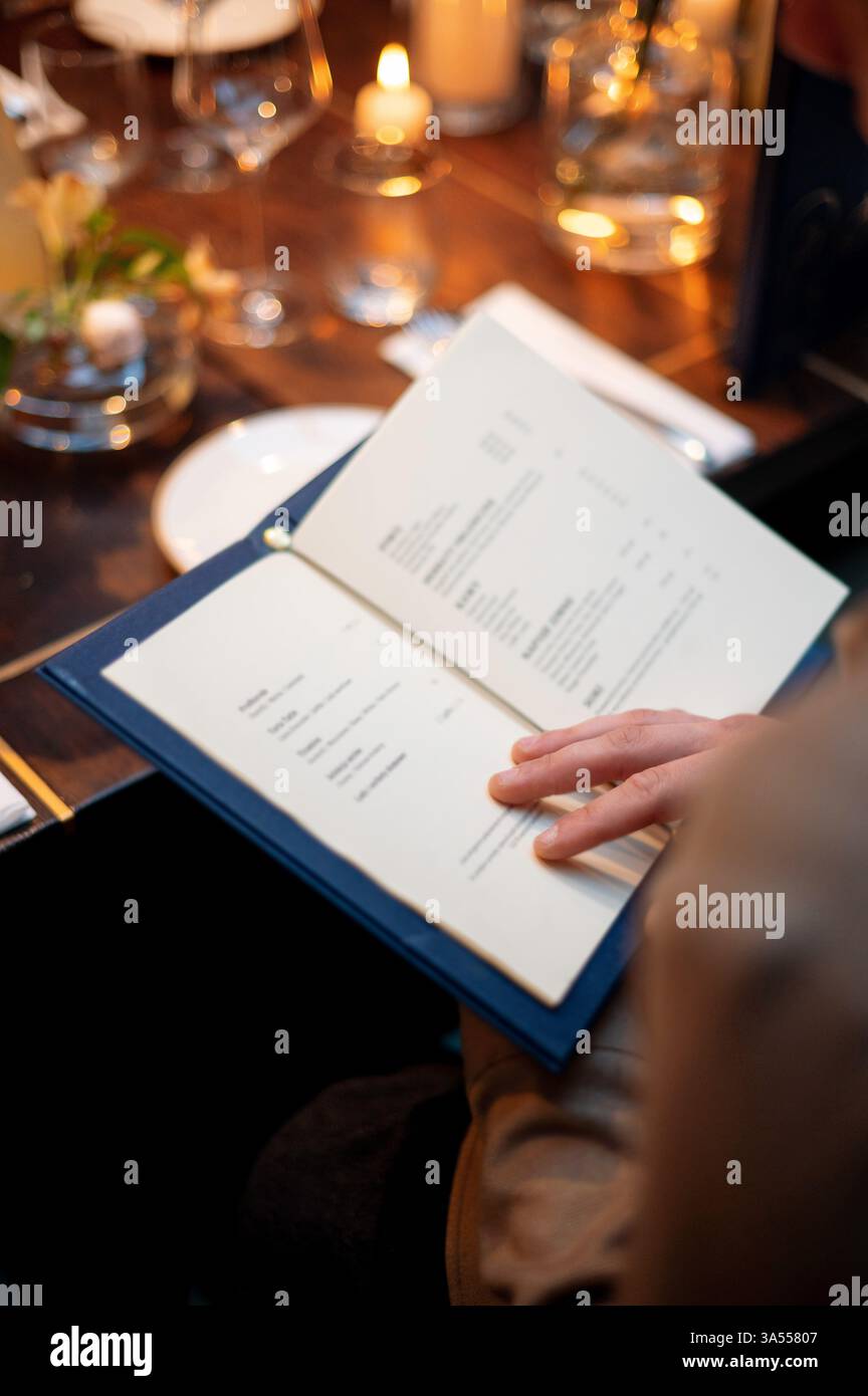 Woman reading a menu in a restaurant. Selective focus on the book Stock ...