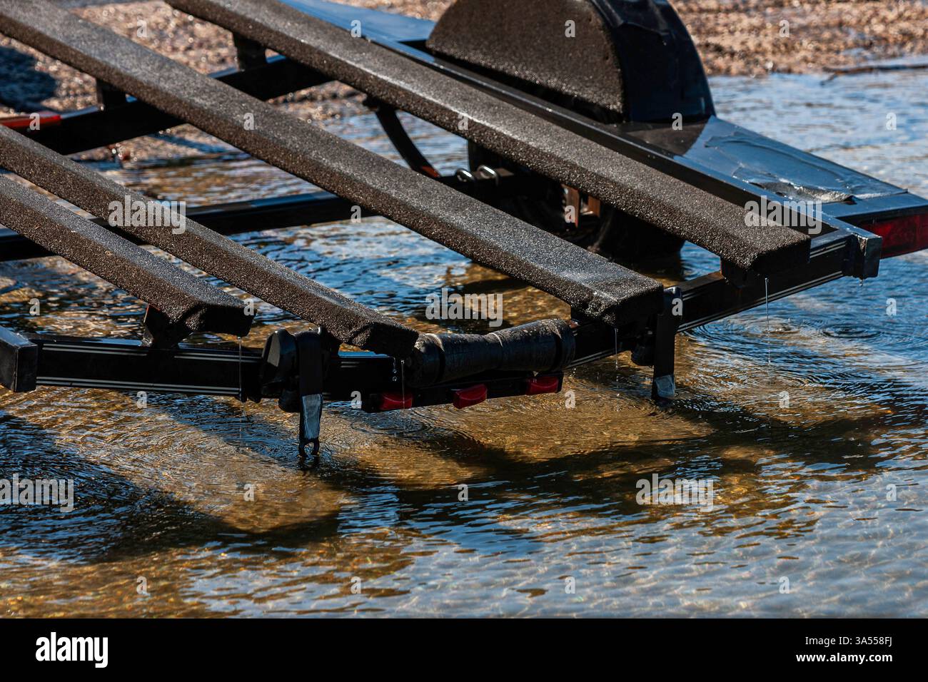 A boat trailer at boat ramp dripping water fishing boat lake after ...