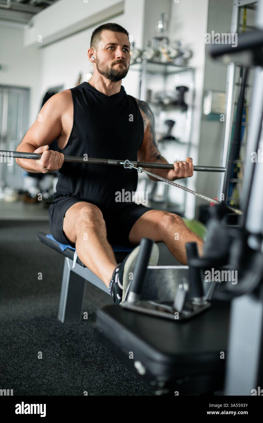 Muscular man performing cable row exercise in the gym Stock Photo - Alamy
