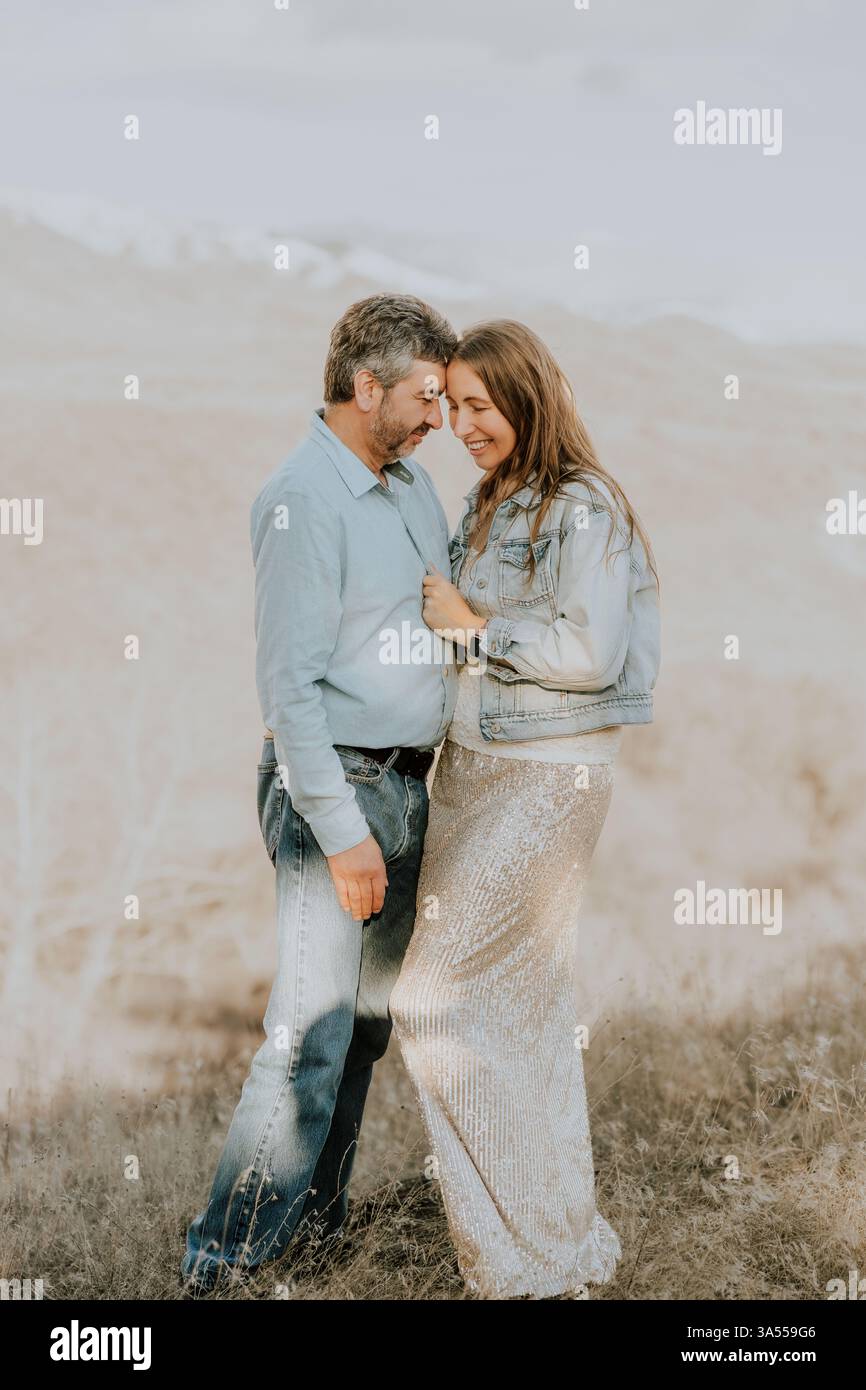 A loving couple stands close, smiling in a natural landscape Stock ...
