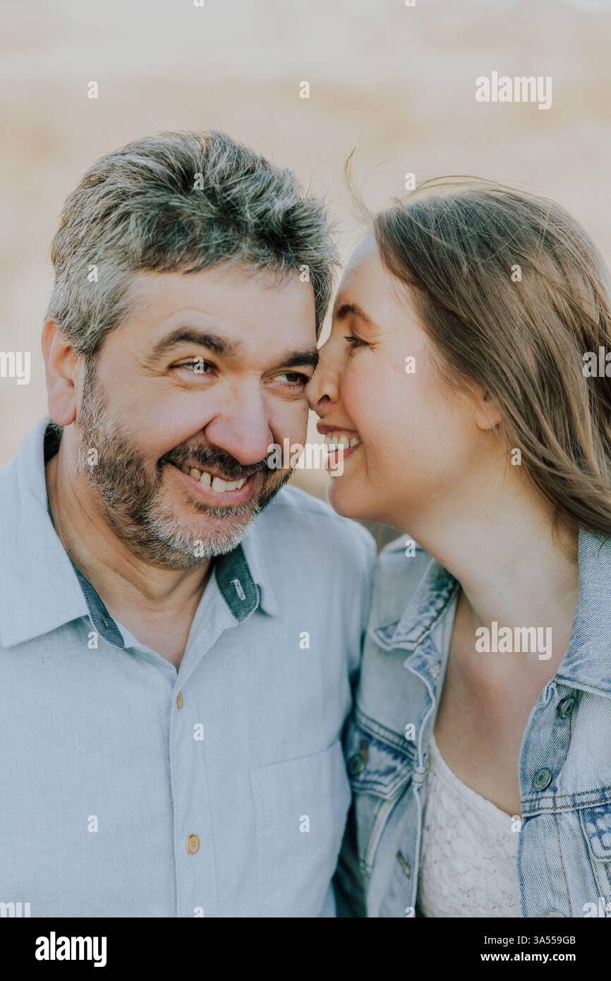 A woman leans in playfully as her partner smiles with joy Stock Photo ...