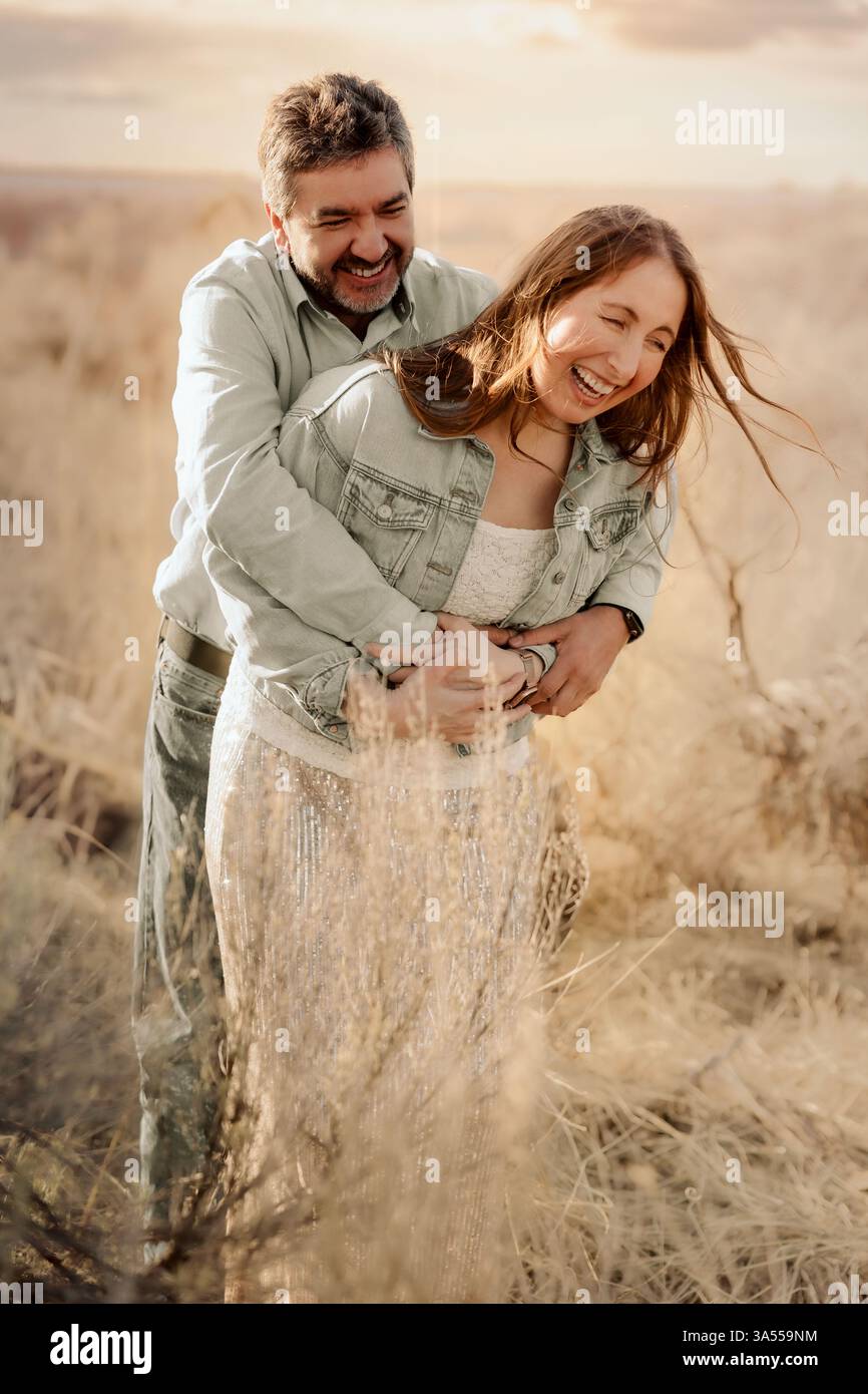 A man embraces his partner as they laugh together Stock Photo - Alamy