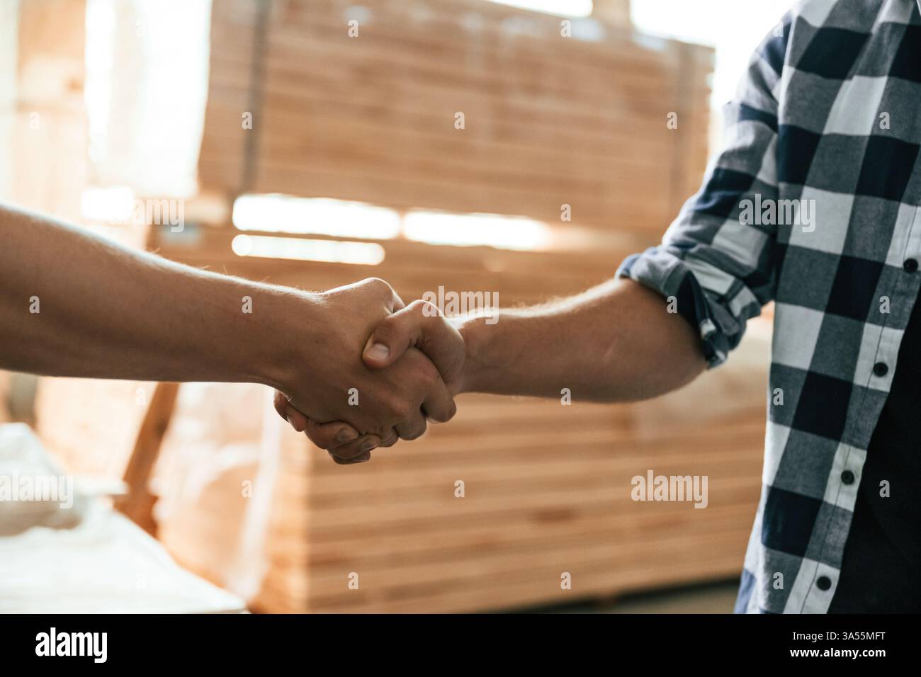 Close up view, doing handshake. Two workers are in the industrial ...