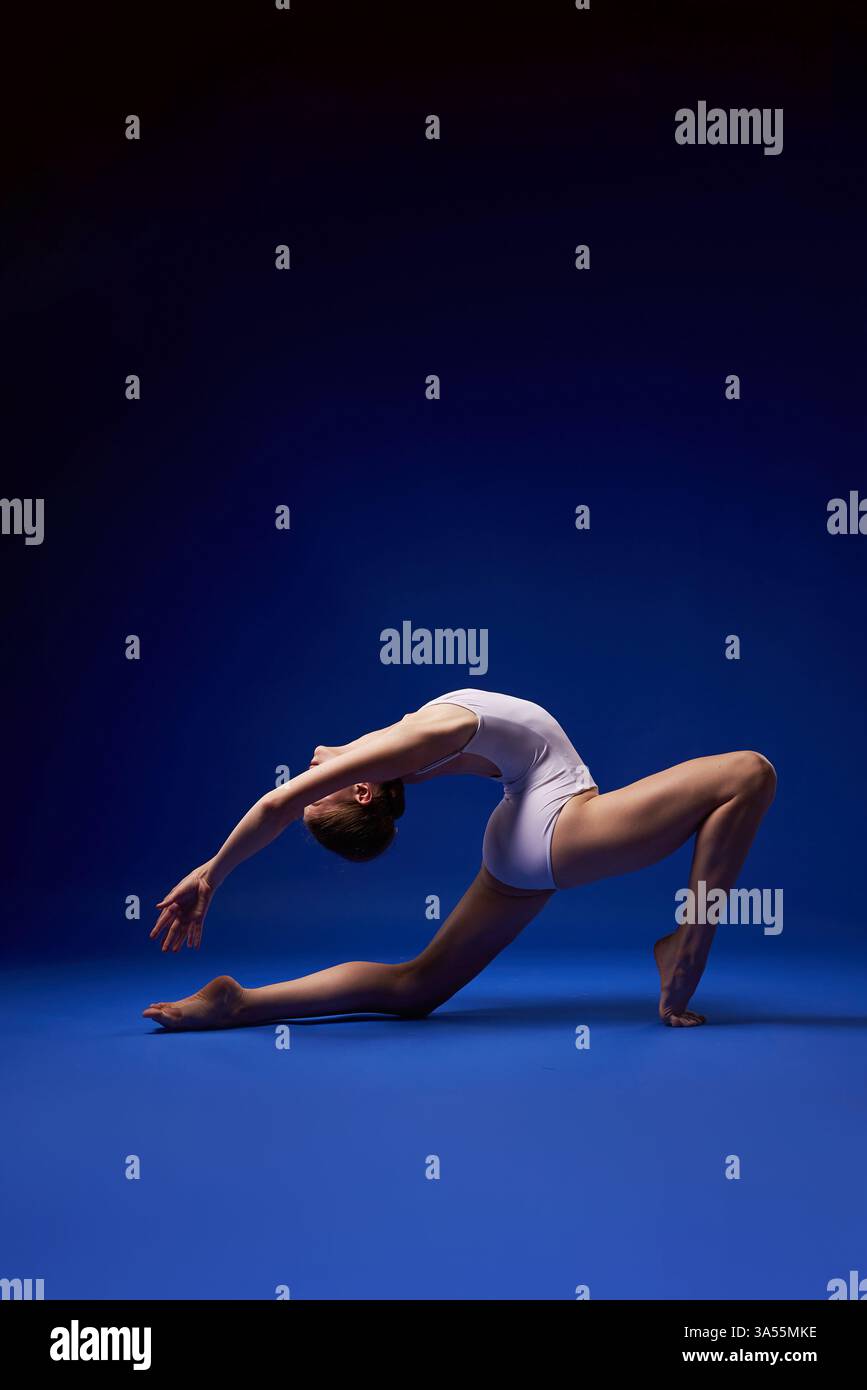 A female gymnast performing a deep backbend, showcasing incredible flexibility and strength ...