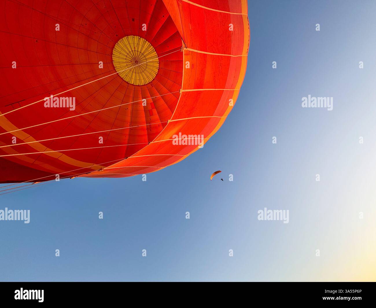 Hot air balloon ride, Paraglider with motor passes the hot air balloon ...