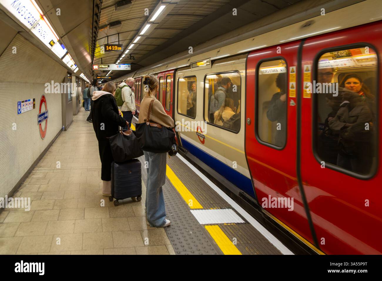 Crowded underground tube train arriving at station platform, Kings ...