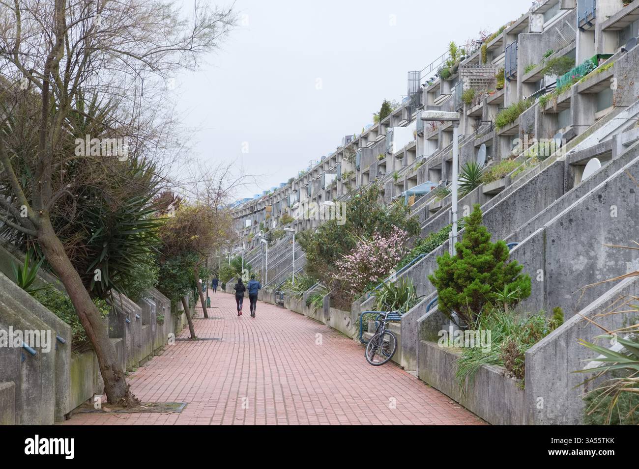 Two people running through Rowley Way on the brutalist style Alexandra ...