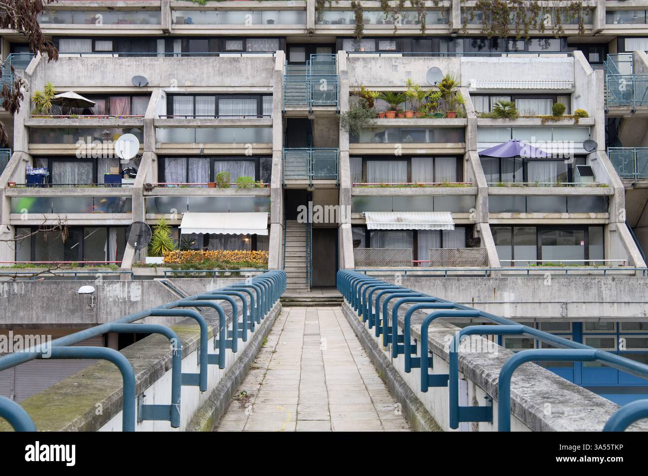 A footbridge with blue railings leading to maisonettes on the brutalist ...