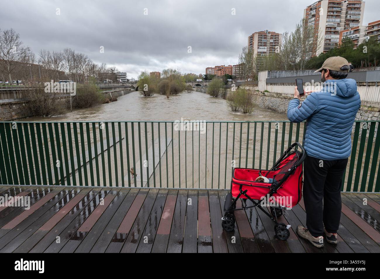 Madrid, Spain. 21st Mar, 2025. A man takes a picture to the Manzanares ...