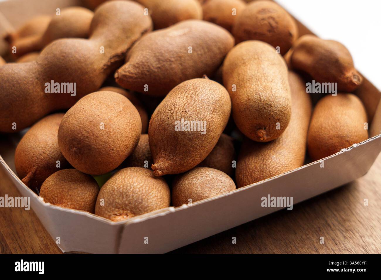 Organic tamarind pods with textured brown shells in recyclable ...