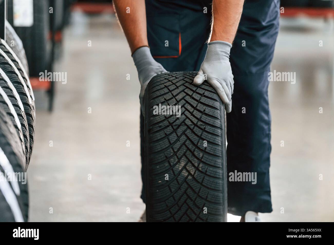 Detailed close up view, moving the wheel. Man is in the tire fitting ...