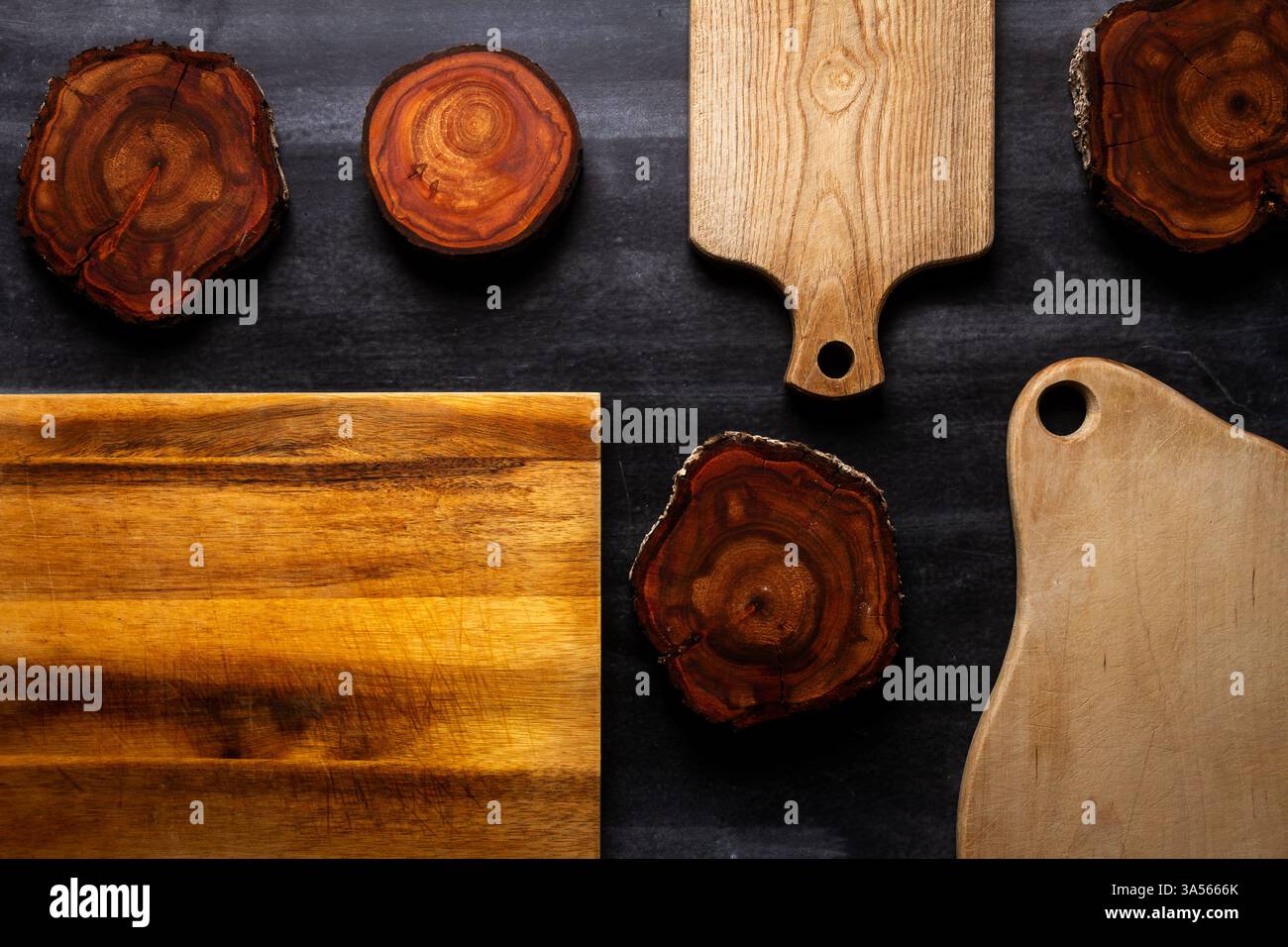Wood log tree slices and cutting boards on black chalkboard. Flat lay ...
