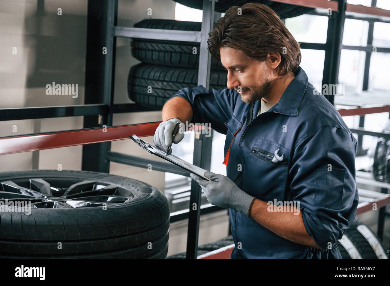 Writing the data into notepad. Man is in the tire fitting car service ...
