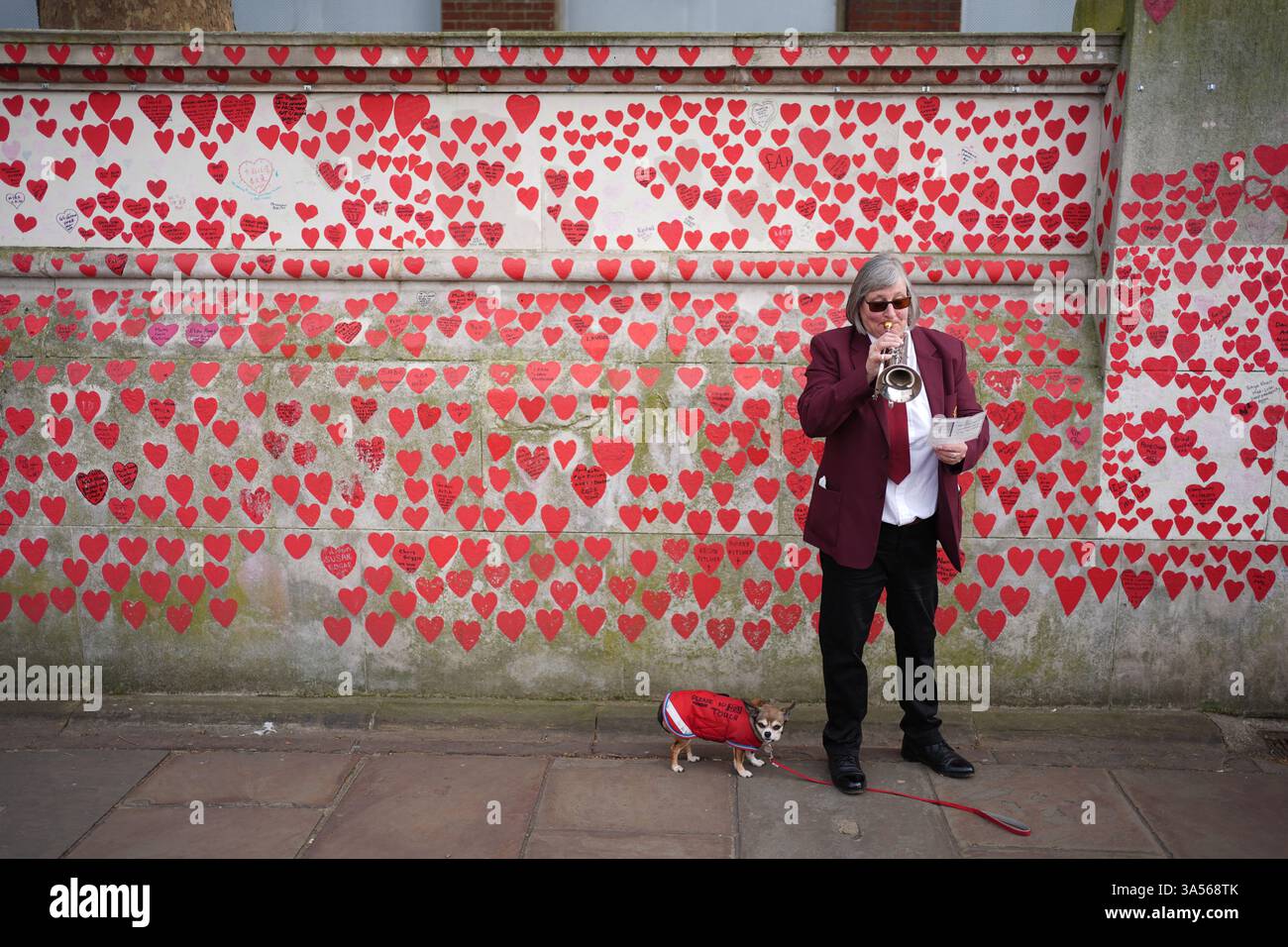 Janet Elaine Berry, with her dog Lizzie, playing a trumpet at the Covid ...