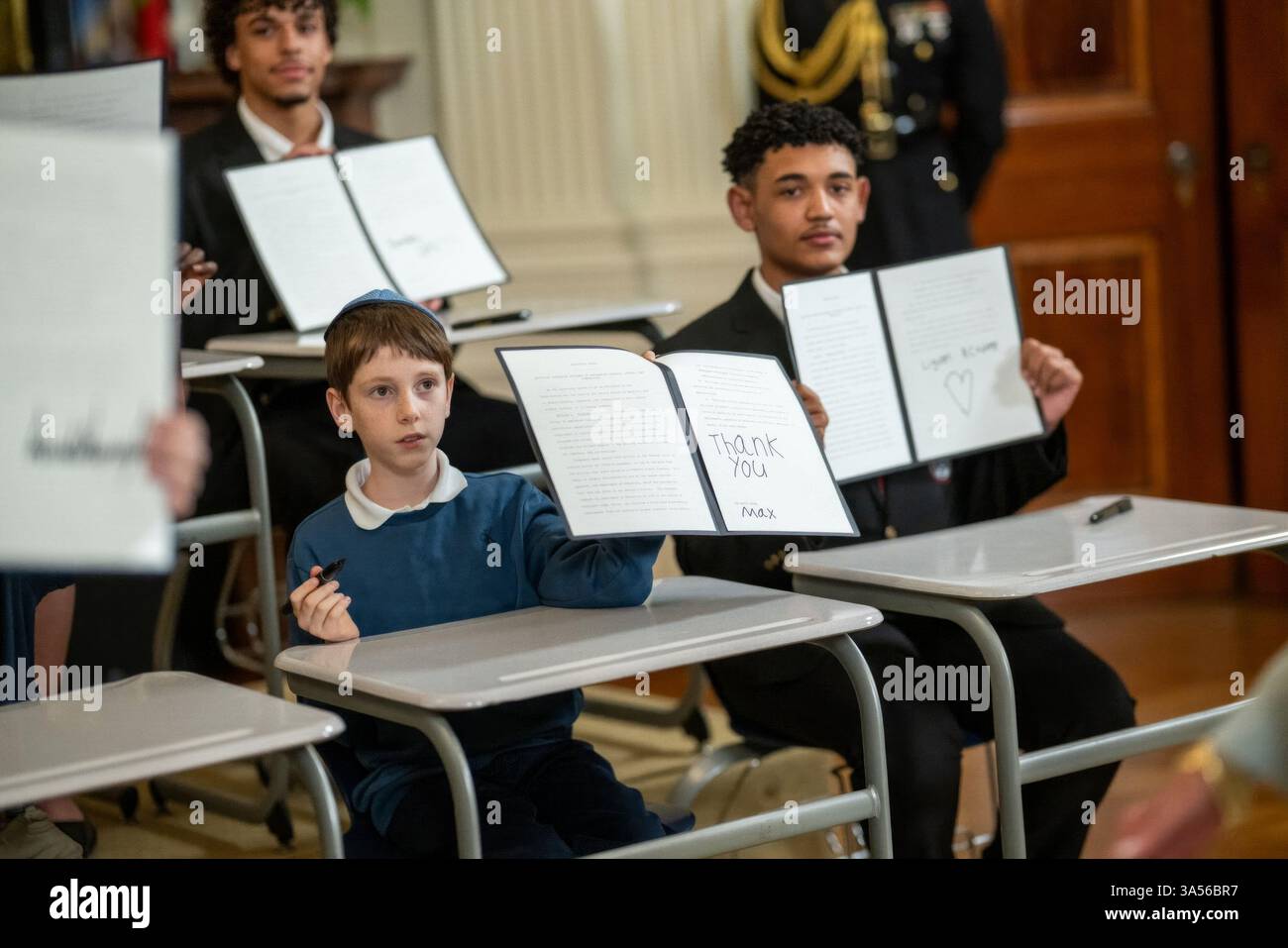 Washington, United States. 20th Mar, 2025. School children hold up ...