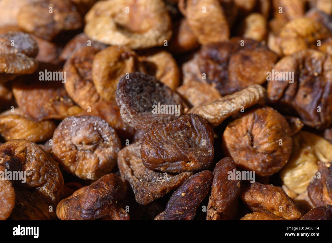 A vibrant display of dried figs reveals their glossy surfaces and rich ...
