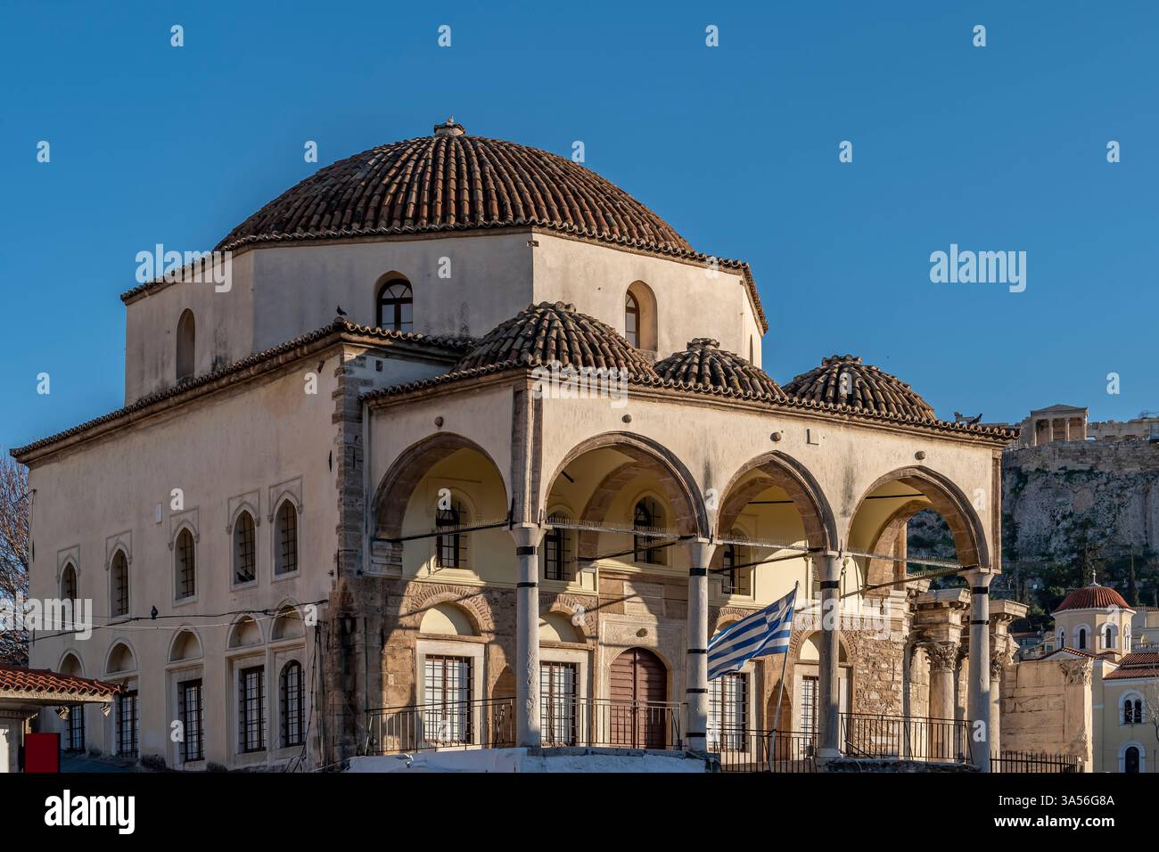 The Greek flag flies in front of the Tzistarakis Mosque, Athens, Greece ...
