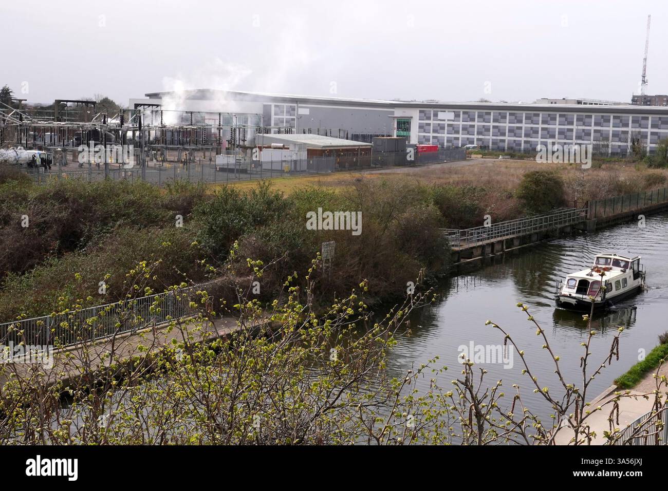 A boat passes as smoke rises from the North Hyde electrical substation ...