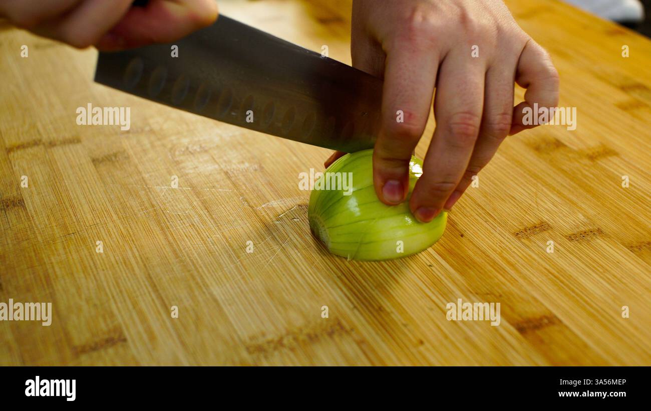 An onion gets chopped, sliced and diced on a wooden counter top in a ...