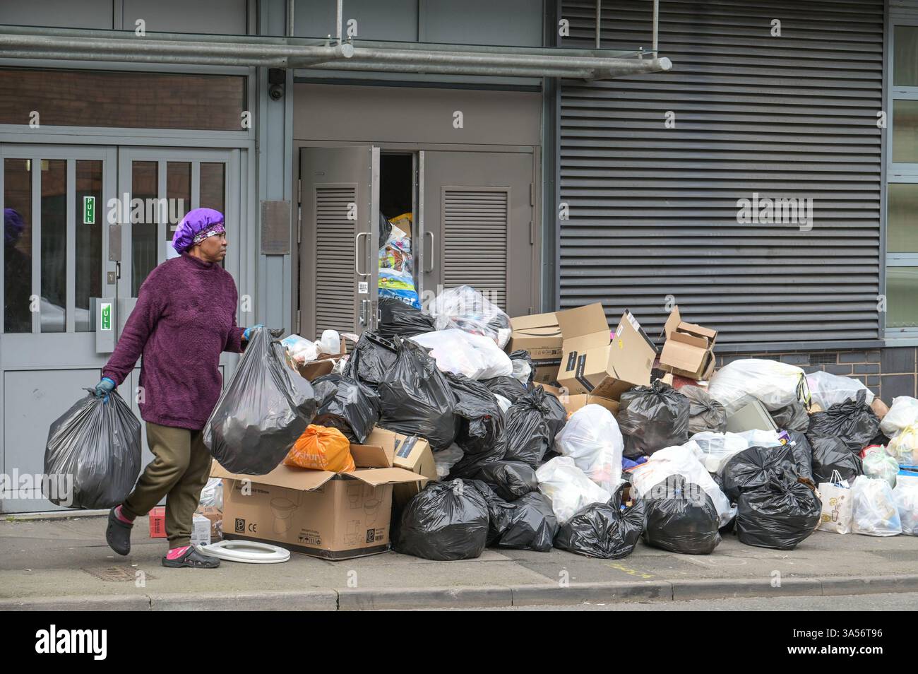 Holliday Street, Birmingham 21st March 2025: A cleaner throws bin bags ...