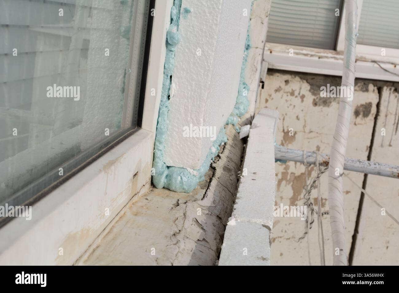 Fastening polystyrene foam to the building facade with polyurethane foam. Preparing the facade ...