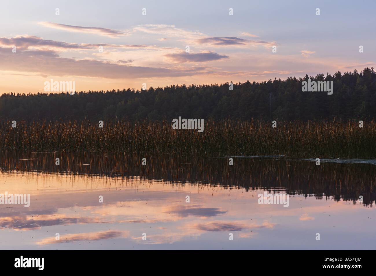 Peaceful lake setting during a sunset, featuring reflections of the ...
