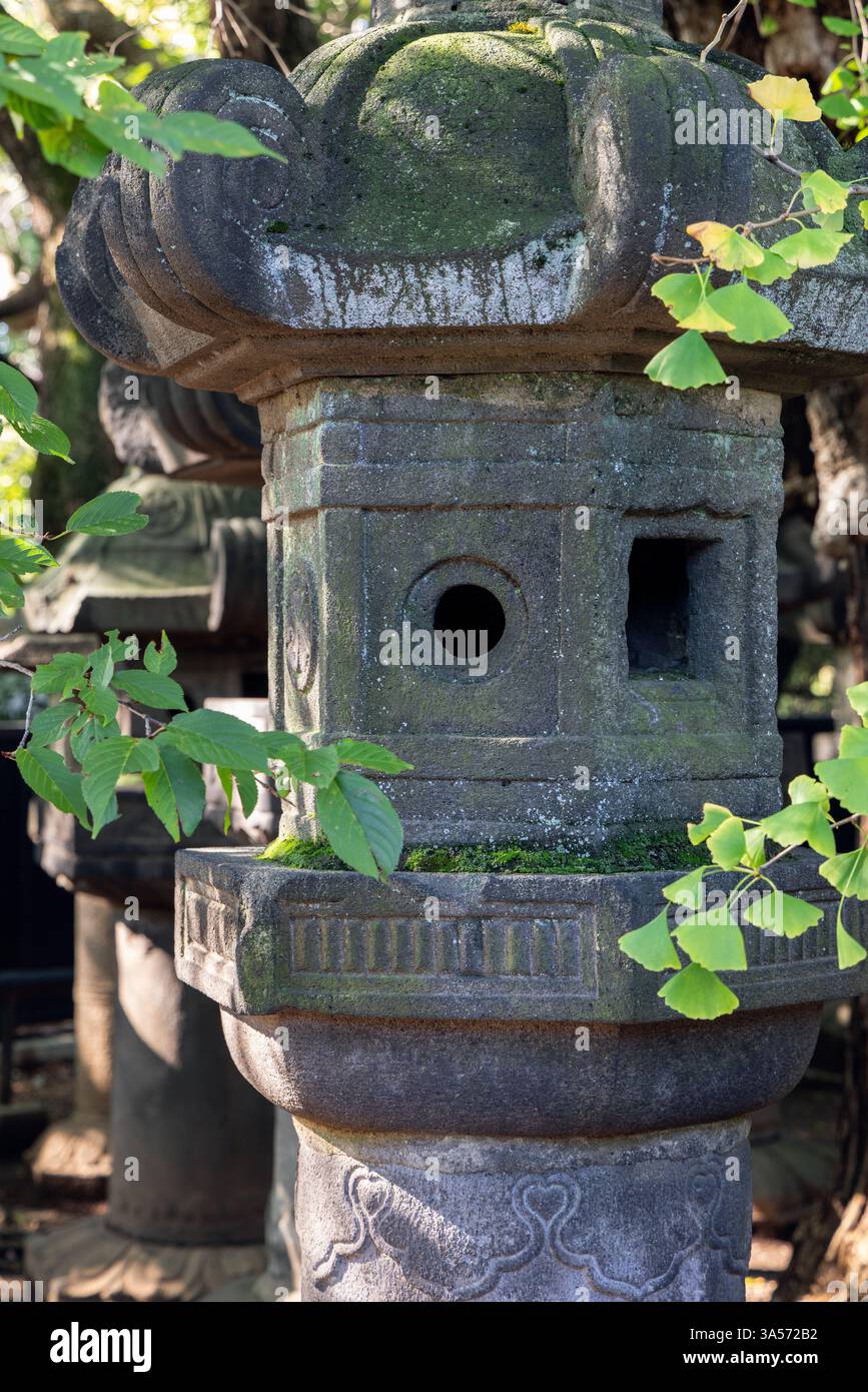 Traditional Japanese stone lantern with detailed engravings shows signs ...