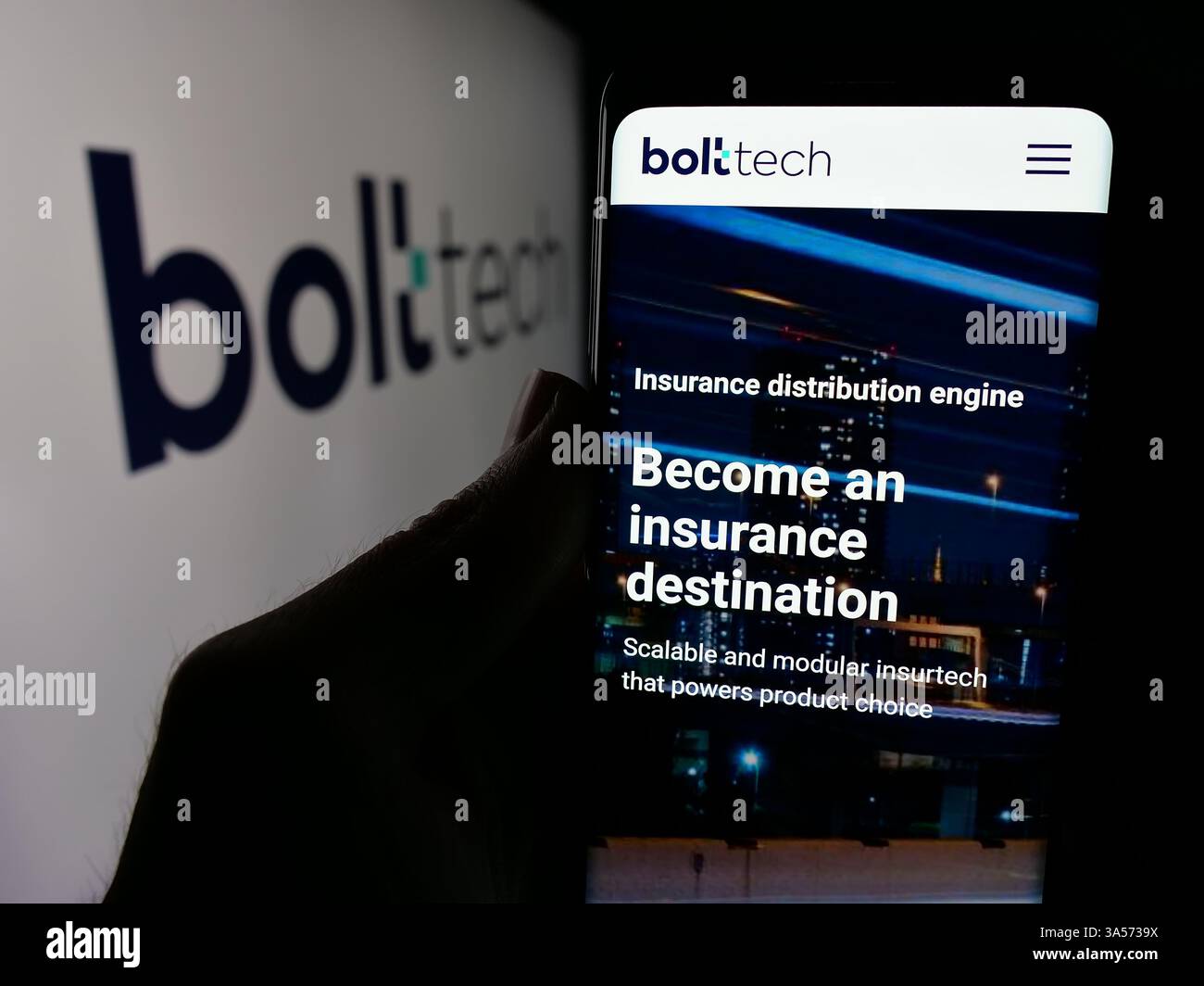 Stuttgart, Germany - 11-17-2024: Person holding cellphone with webpage of Singaporean insurtech ...