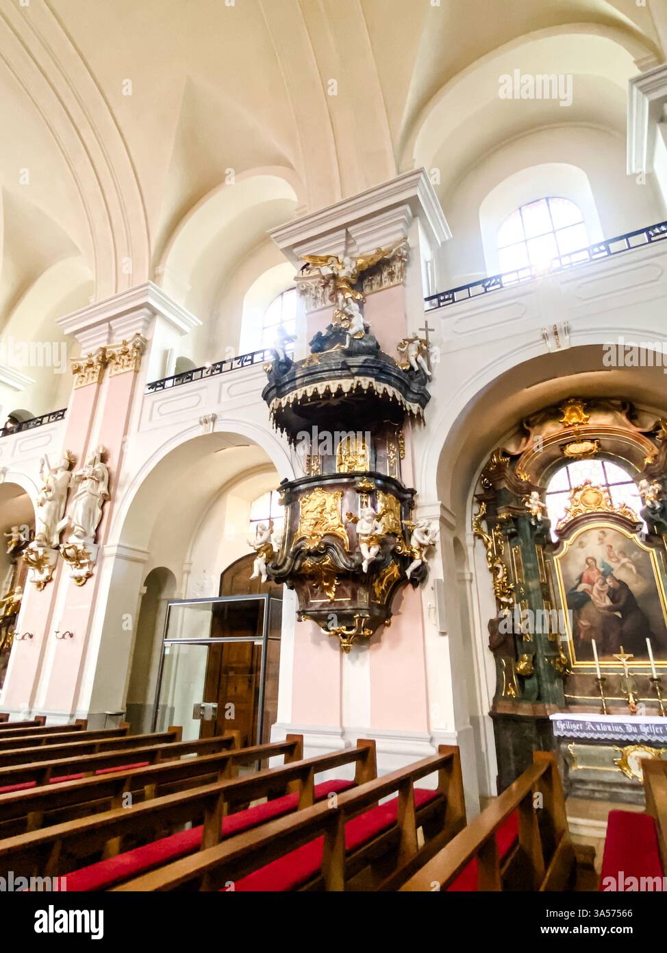 The interior of a church is decorated with gold and white, and the ...