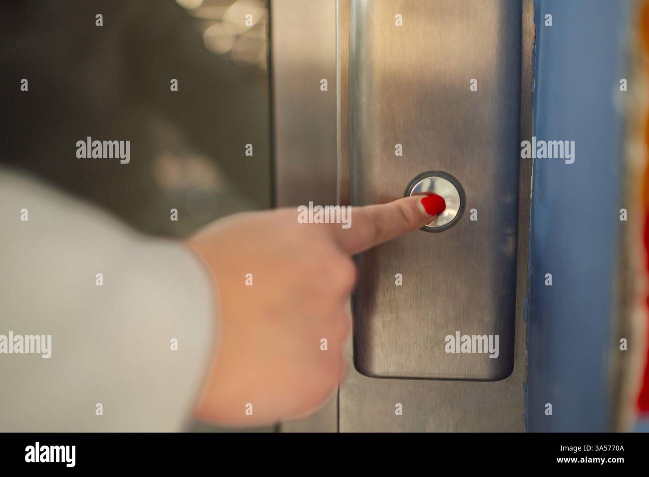 Hand pressing an elevator button in a modern building hallway Stock ...