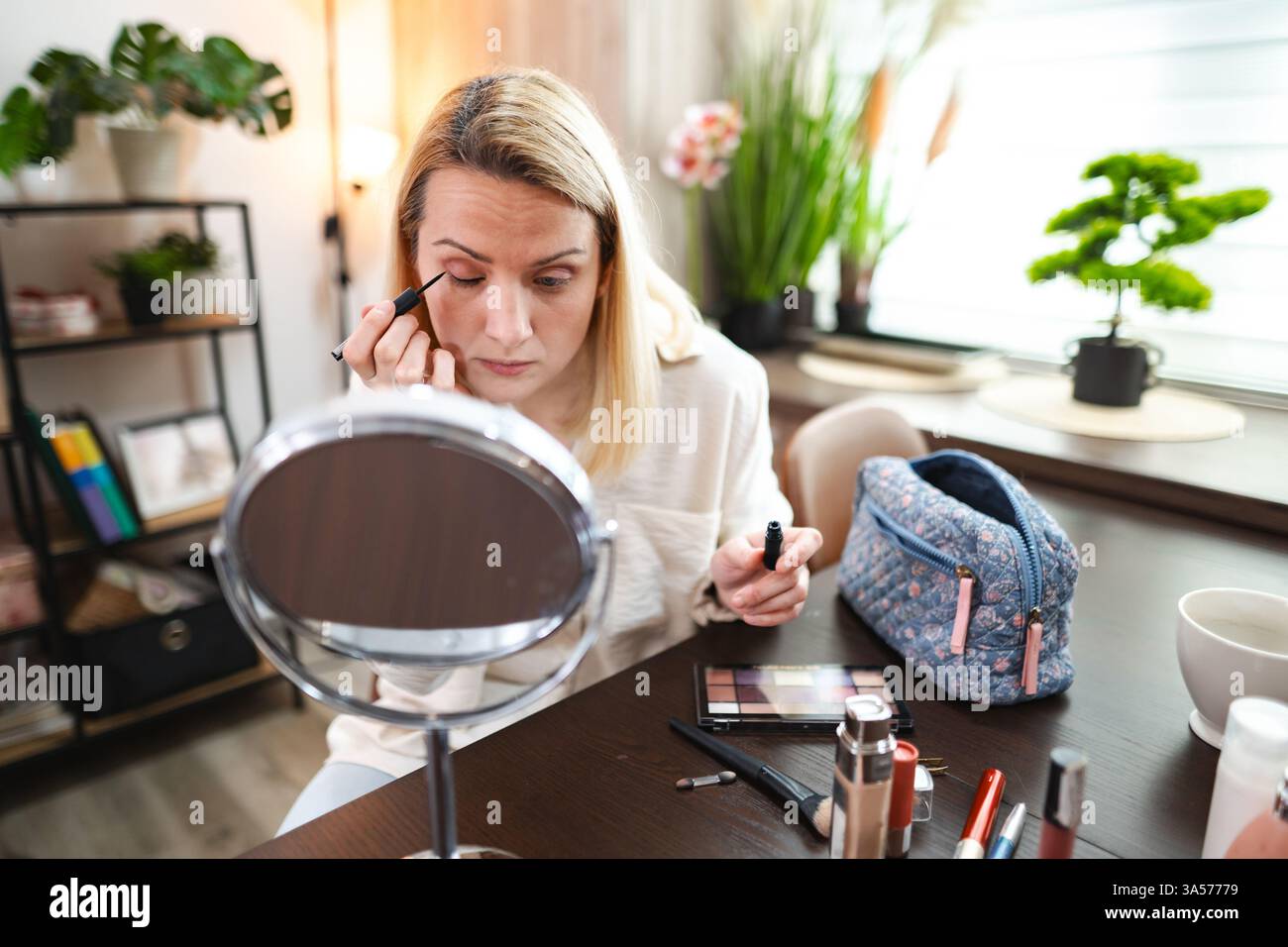 Applying makeup skillfully in a cozy indoor space with natural light ...