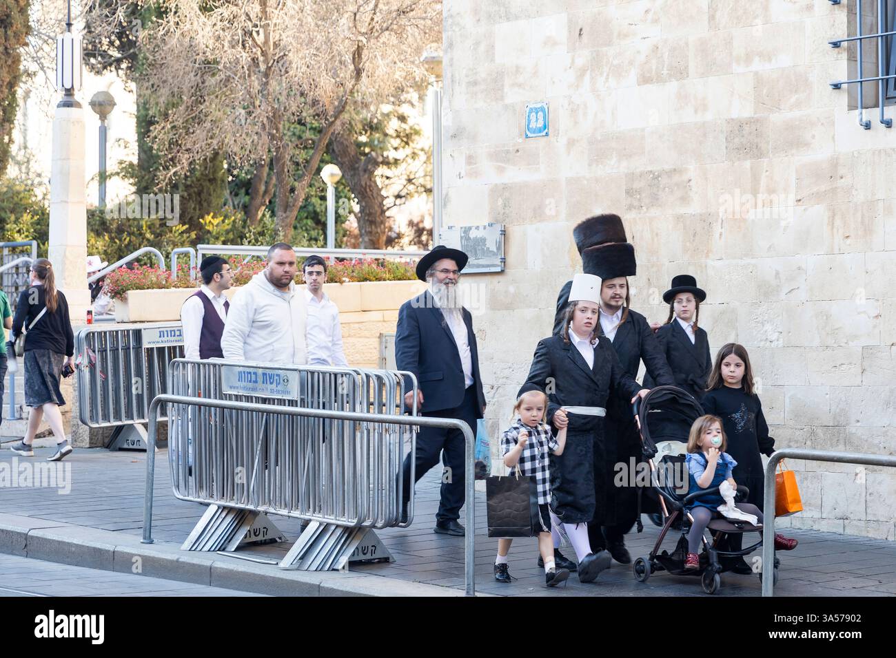 Jerusalem, Israel – March 16, 2025. Hasidic men in hats walk on the ...