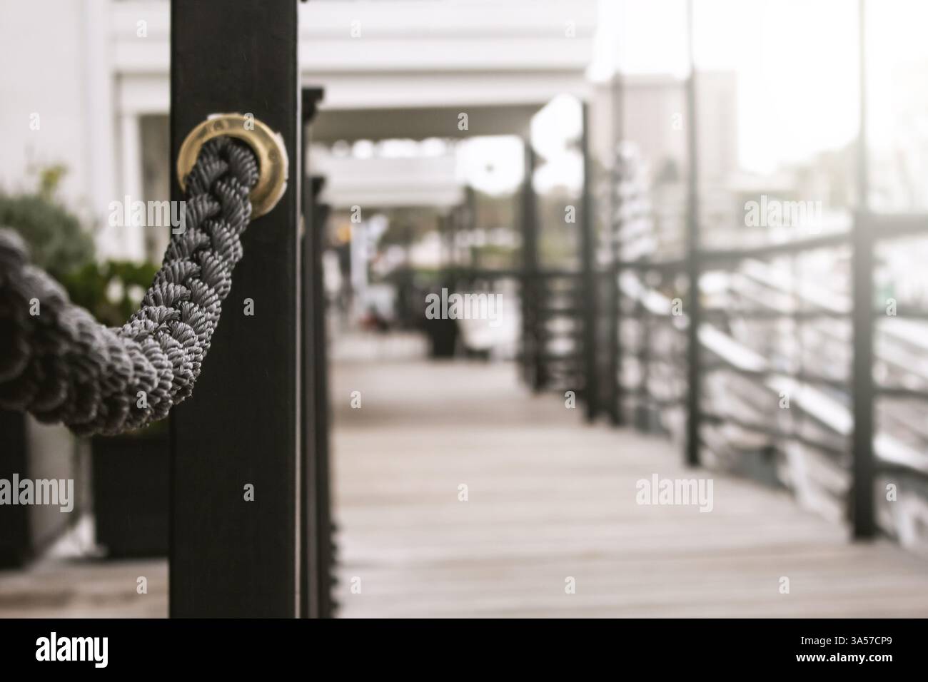 A view of a modern harbor boardwalk area, featuring a rope fence Stock ...