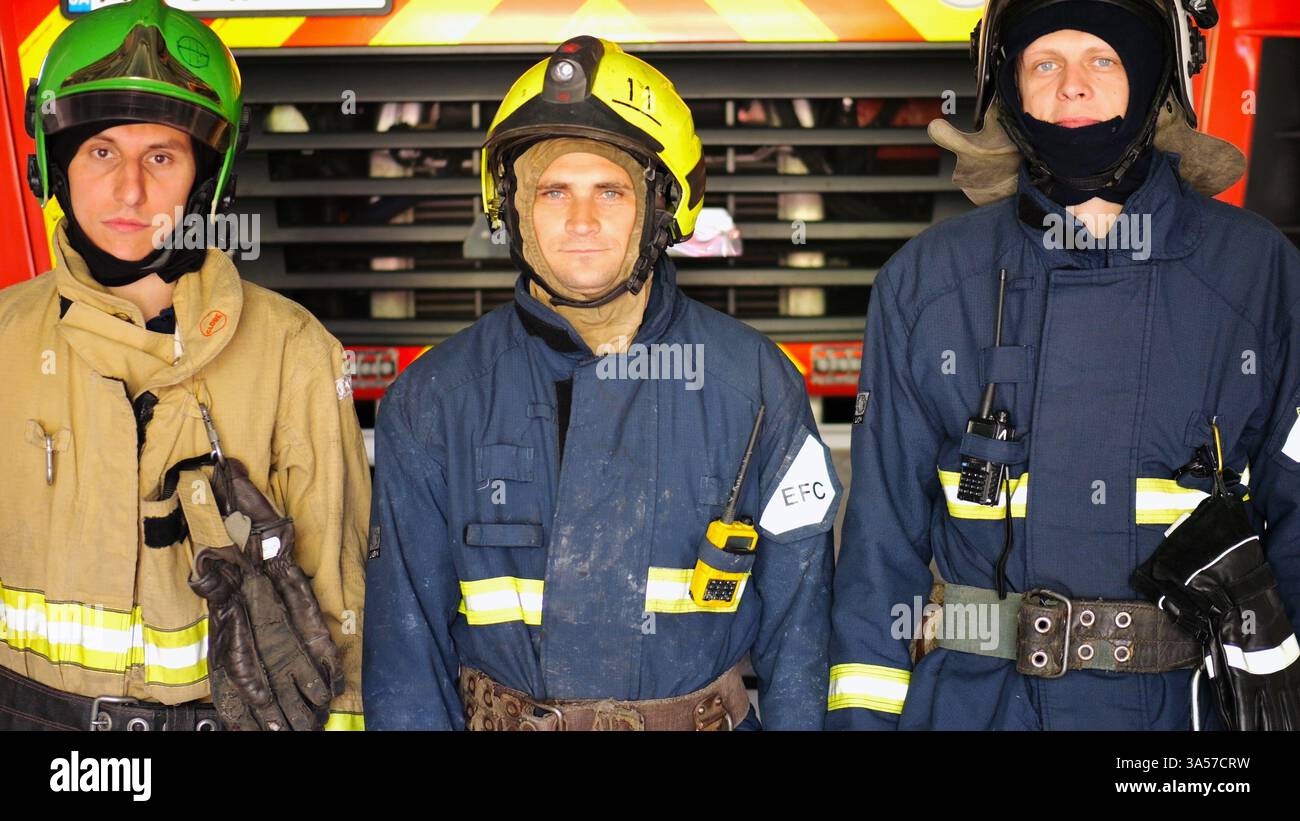 Portrait of male firefighters in helmets and protective uniforms ...