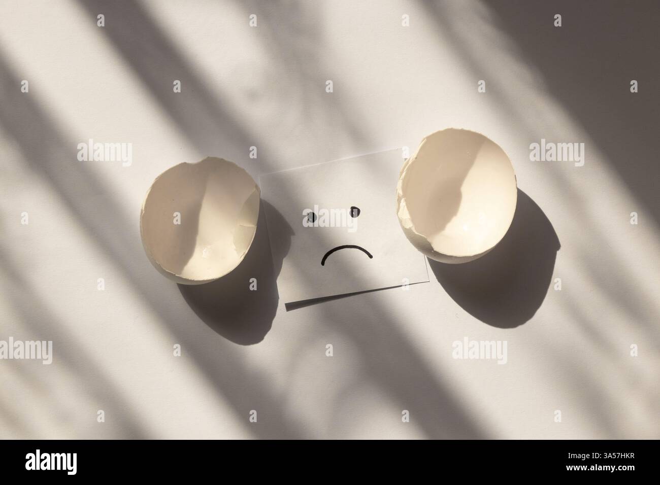 Chicken egg shell broken and sad emotions drawn on paper on white ...