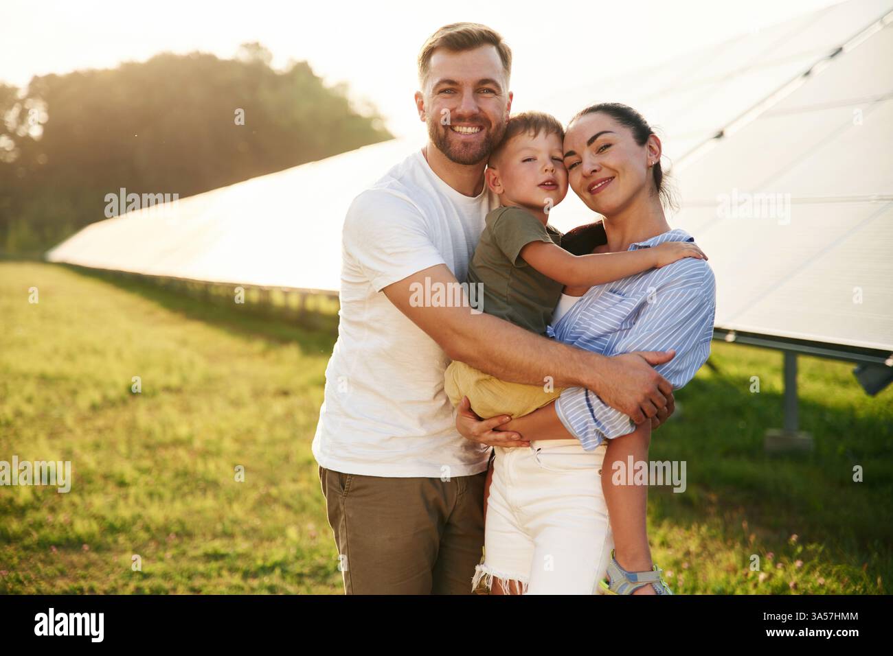 Embracing each other. Father, mother and little son are outdoors near ...