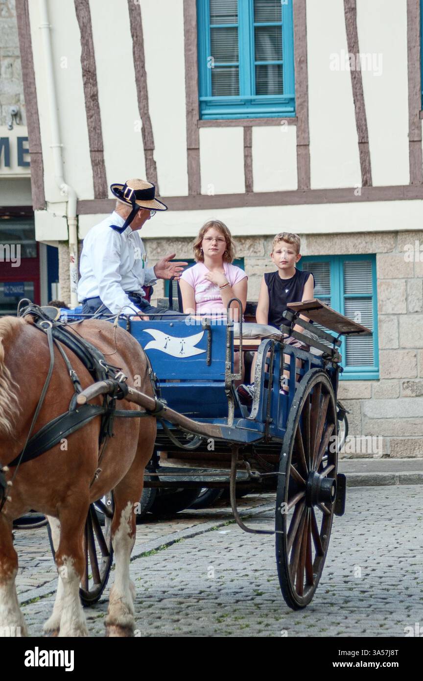 A boy and girl ride in a blue pony and cart in Quimper, France Stock ...