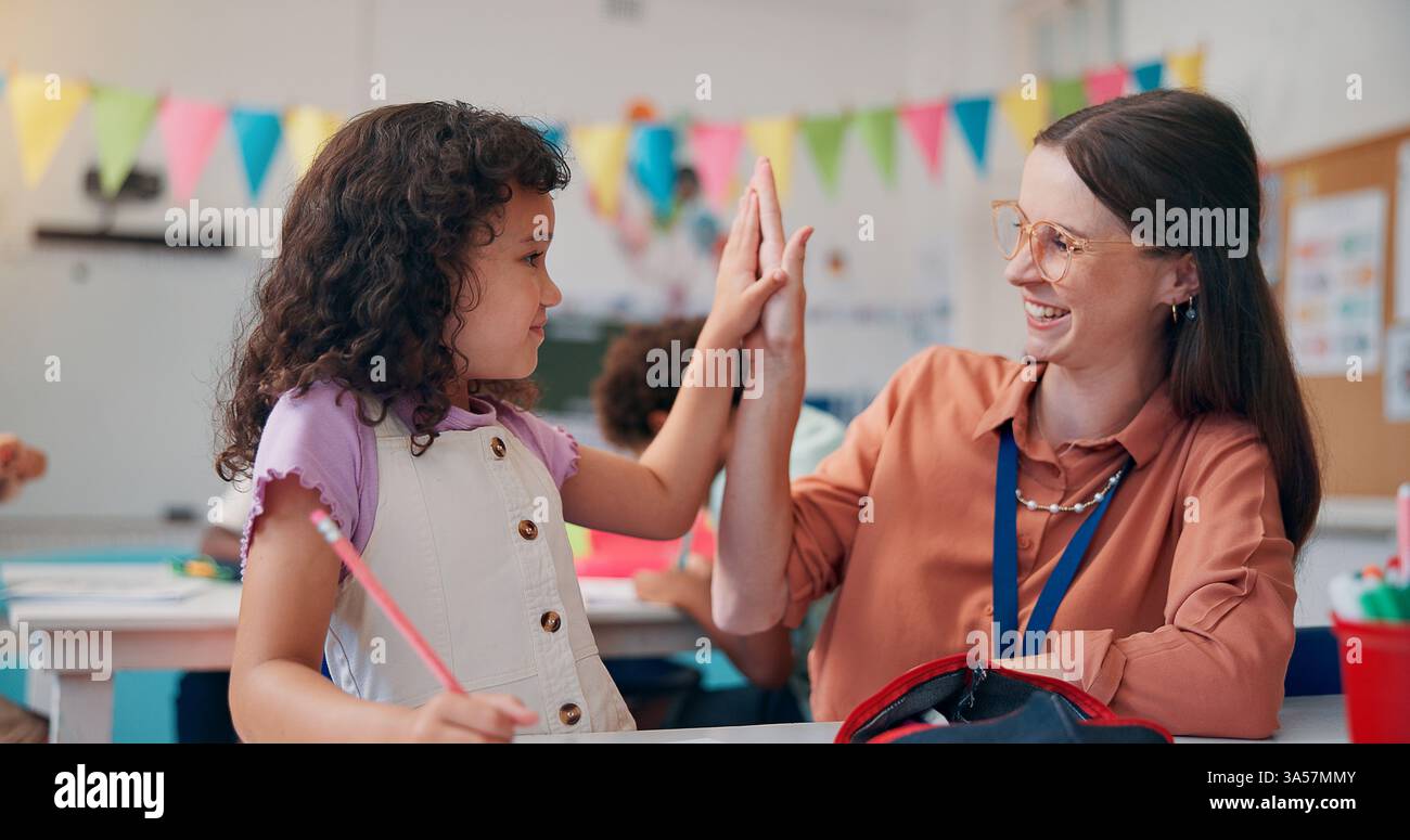Education, teacher and high five student in classroom for lesson ...