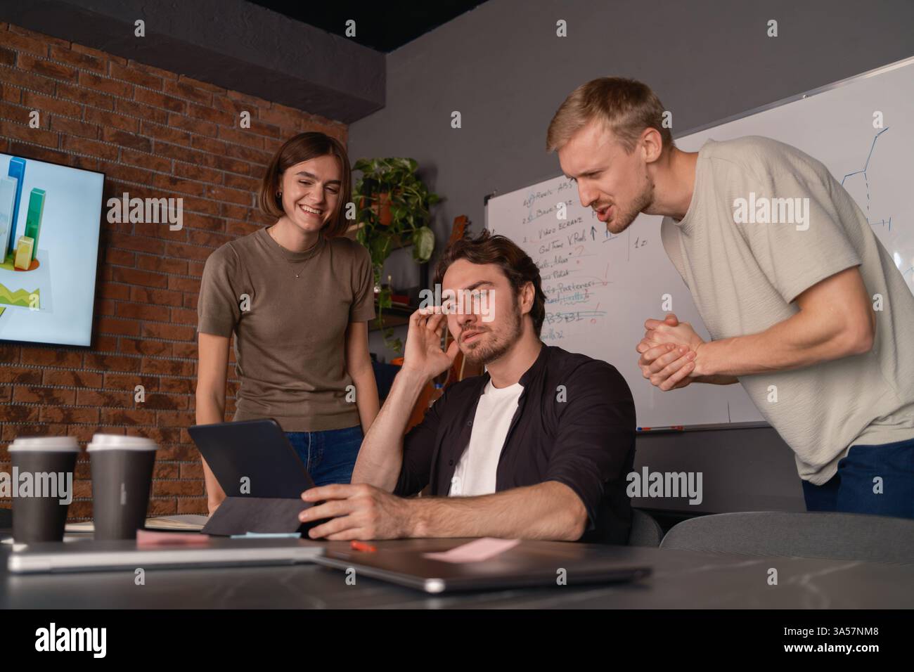 Team collaboration examining progress results during a casual office ...